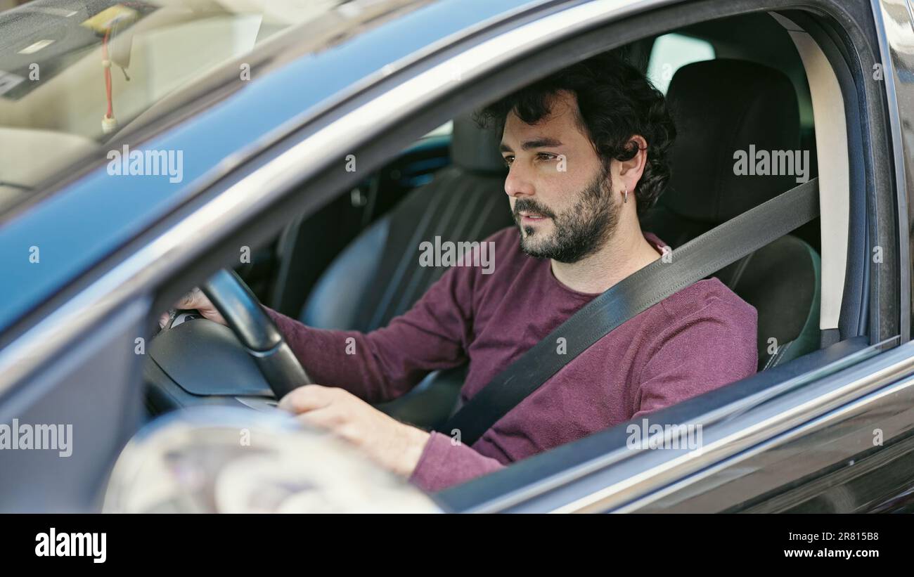 Young hispanic man driving car at street Stock Photo - Alamy