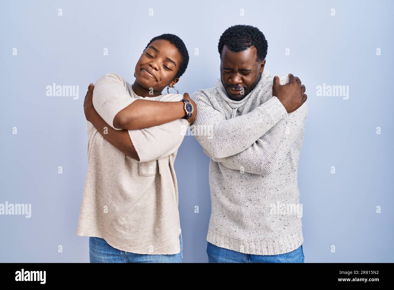 Young african american couple standing over blue background together ...
