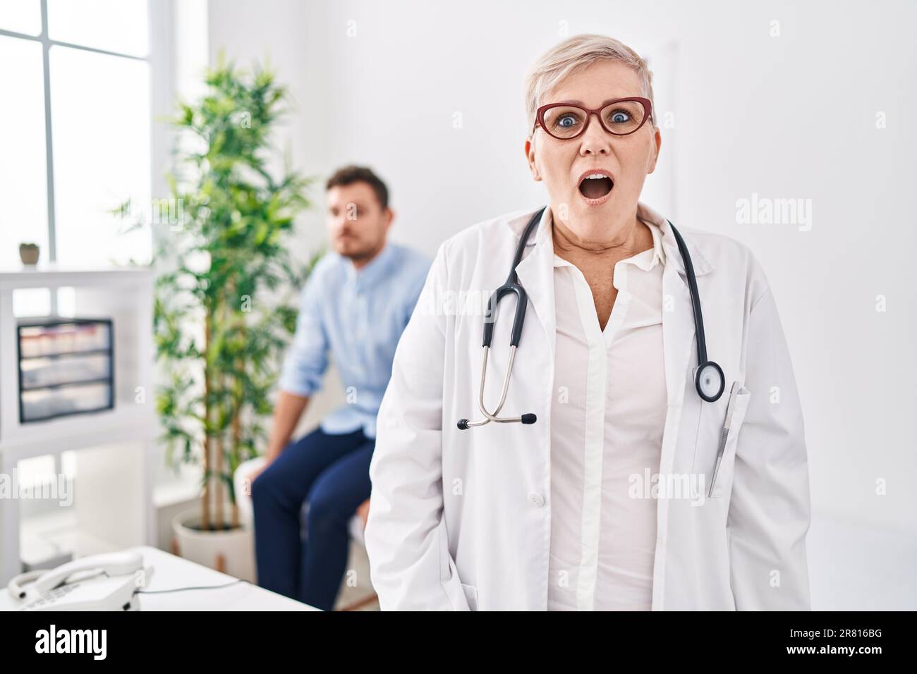 Female doctor wearing uniform and stethoscope at medical clinic scared ...