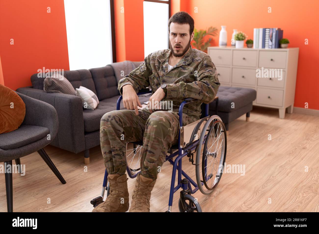 Young hispanic soldier man injured sitting on wheelchair scared and ...