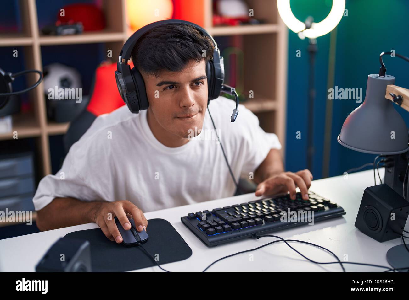 Young hispanic man streamer playing video game using computer at gaming ...
