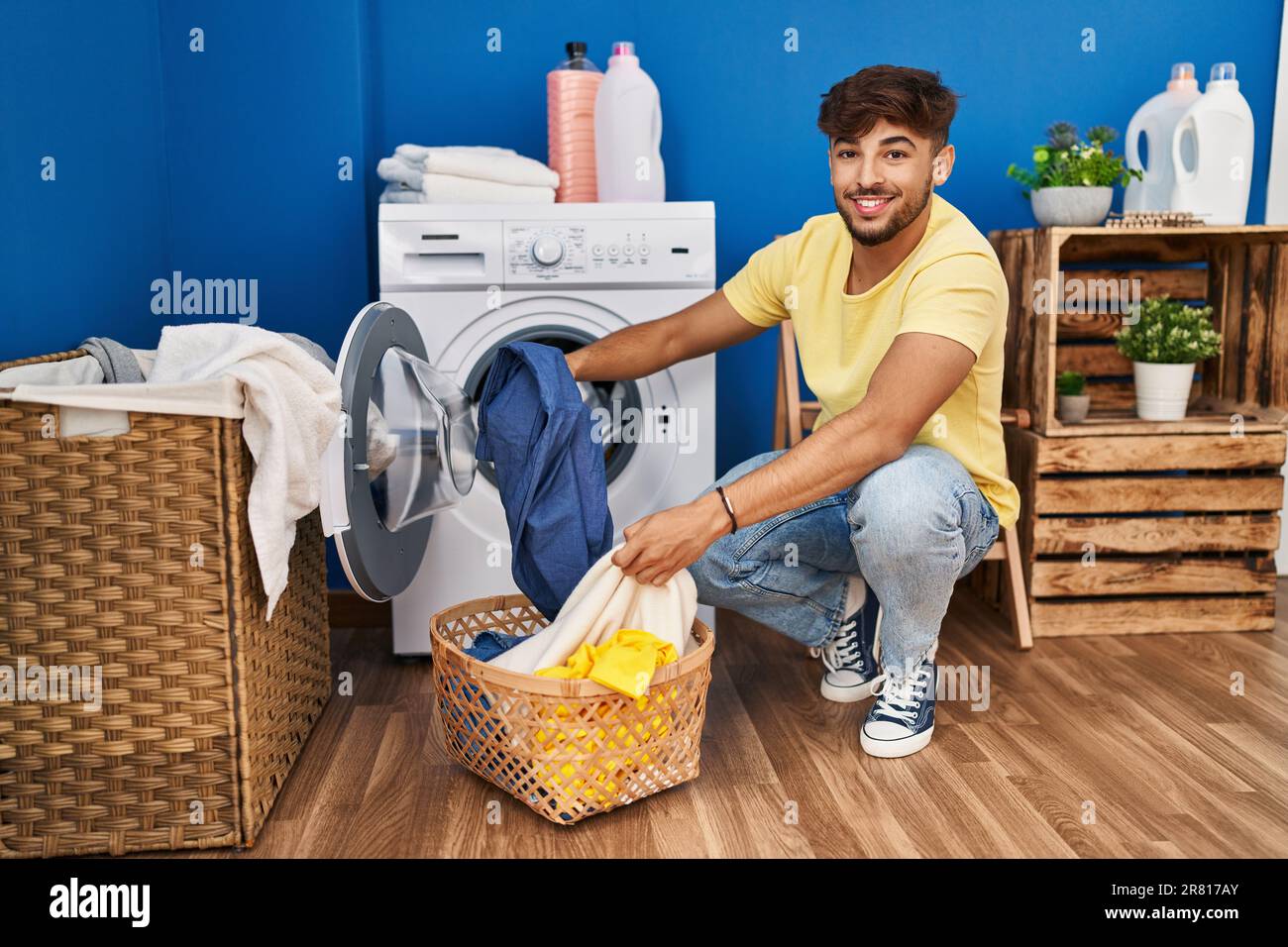 Young arab man smiling confident washing clothes at laundry room Stock ...
