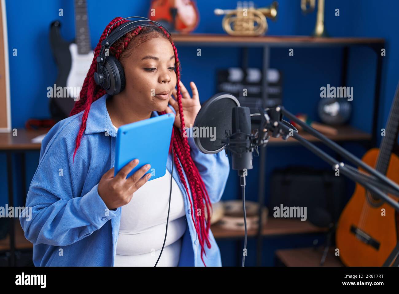 African american woman artist singing song holding touchpad at music ...