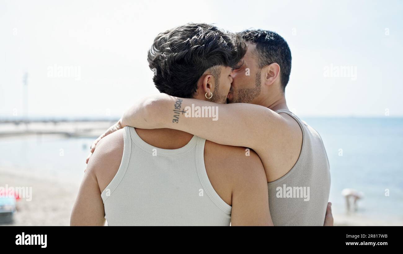 Two Men Couple Hugging Each Other And Kissing Backwards At Seaside
