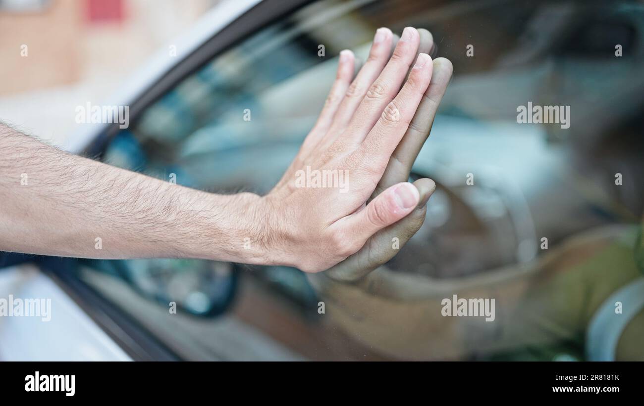 Two men with hands together on car window saying goodbye at park Stock ...