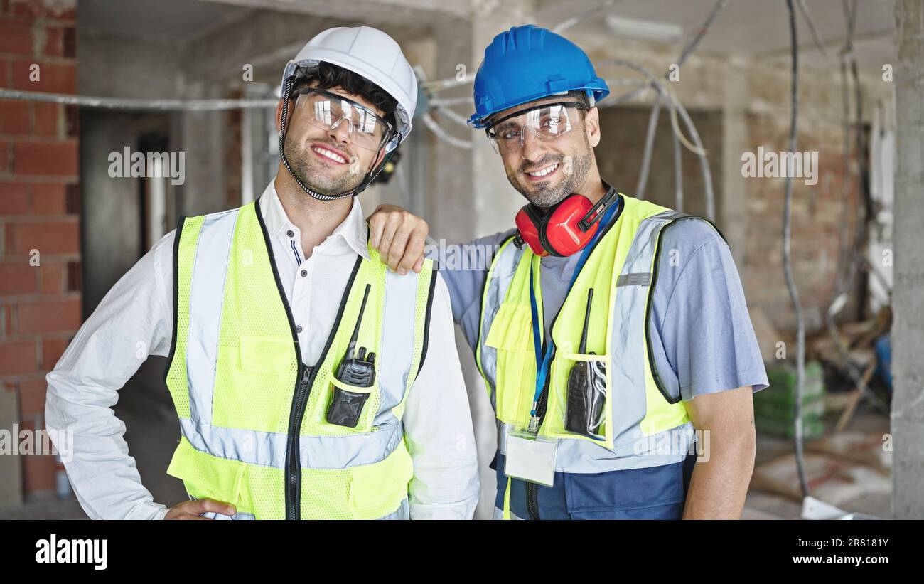 Two men builders smiling confident standing at construction site Stock ...