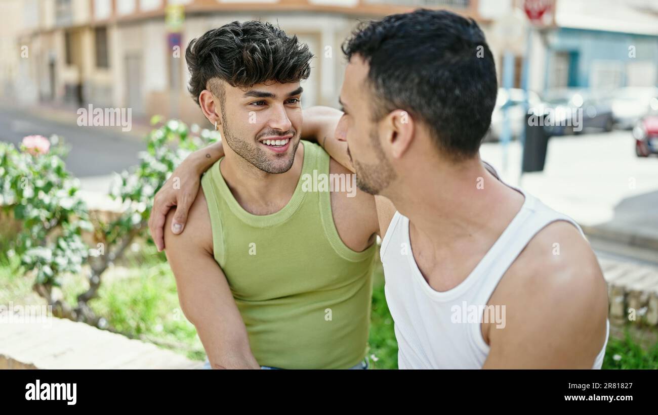 Two men couple hugging each other sitting on bench at park Stock Photo ...