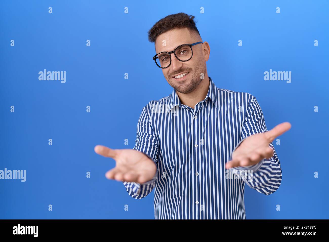 Hispanic man with beard wearing glasses smiling cheerful offering hands ...