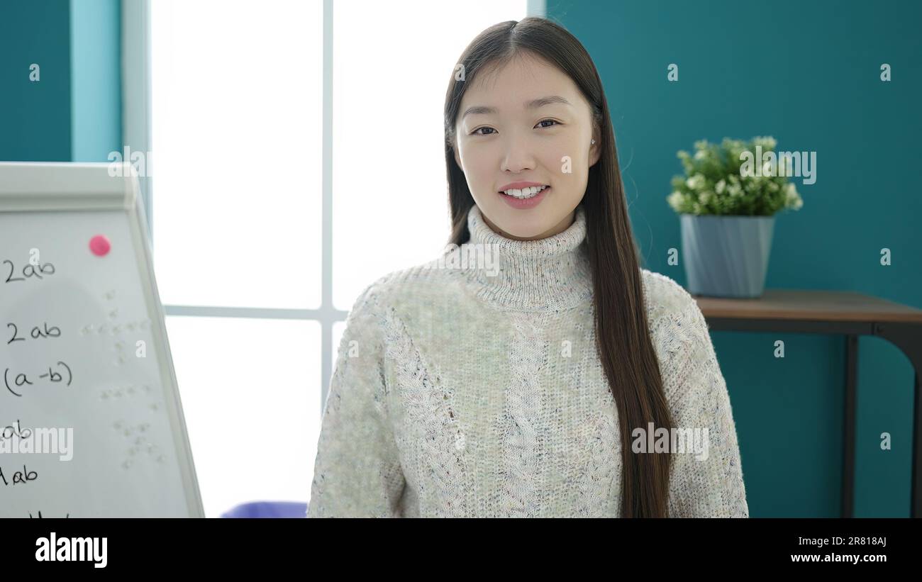 Young chinese woman student smiling confident standing at library ...