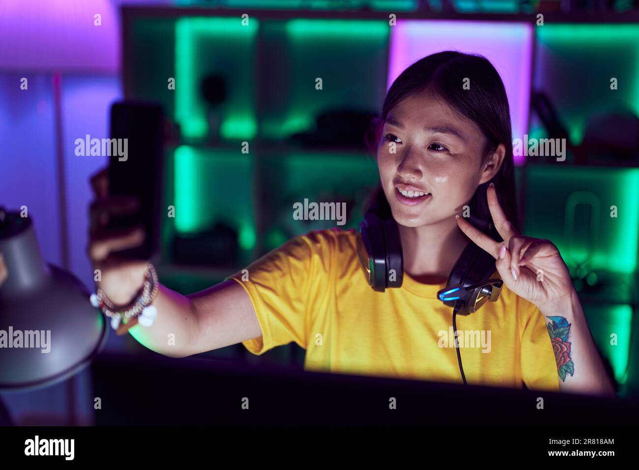 Chinese woman streamer wearing headset make selfie by smartphone at ...