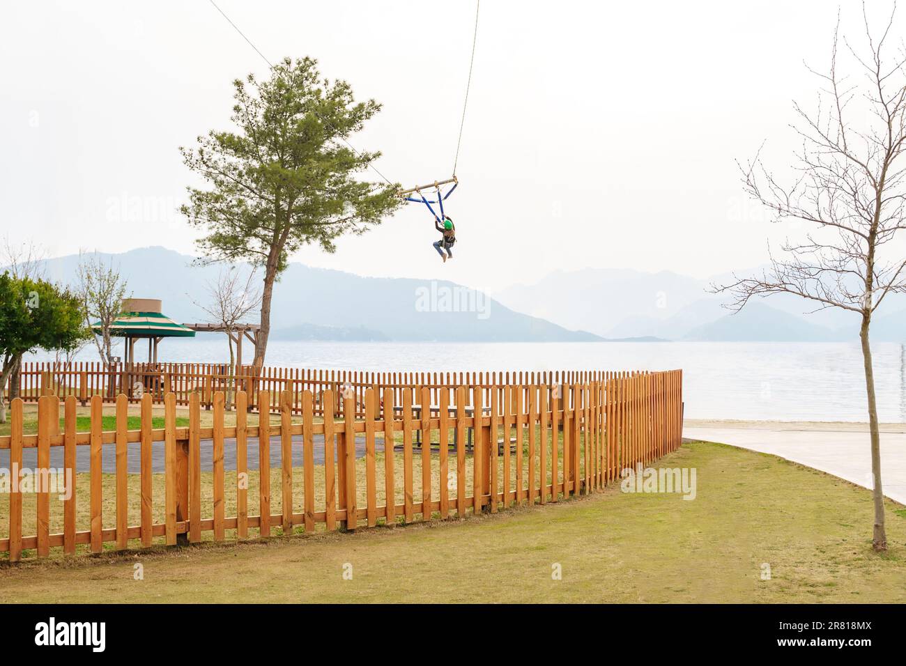 Teenage teen girl bungee flying in rope amusement park. Climbing ...