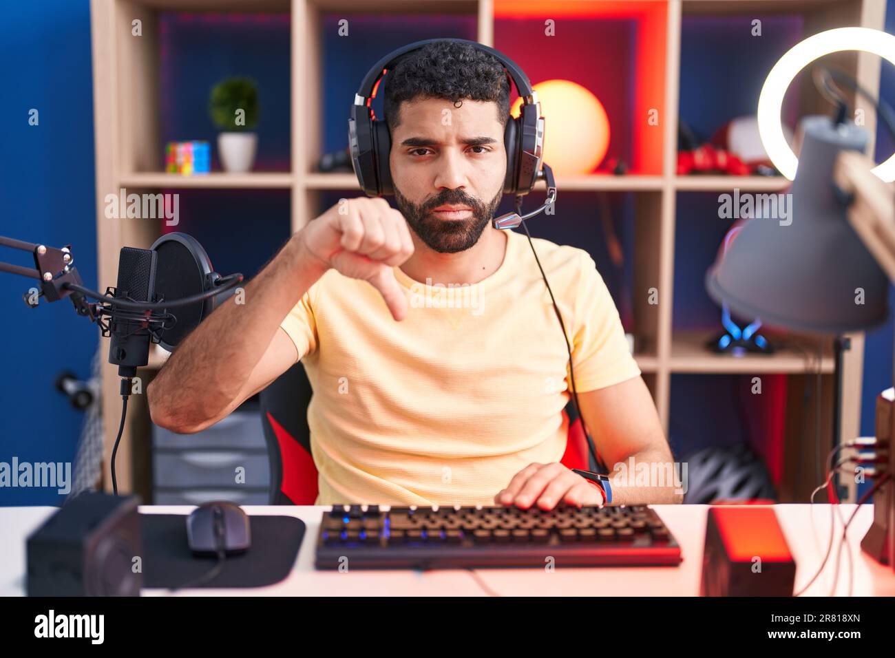 Hispanic man with beard playing video games with headphones looking ...