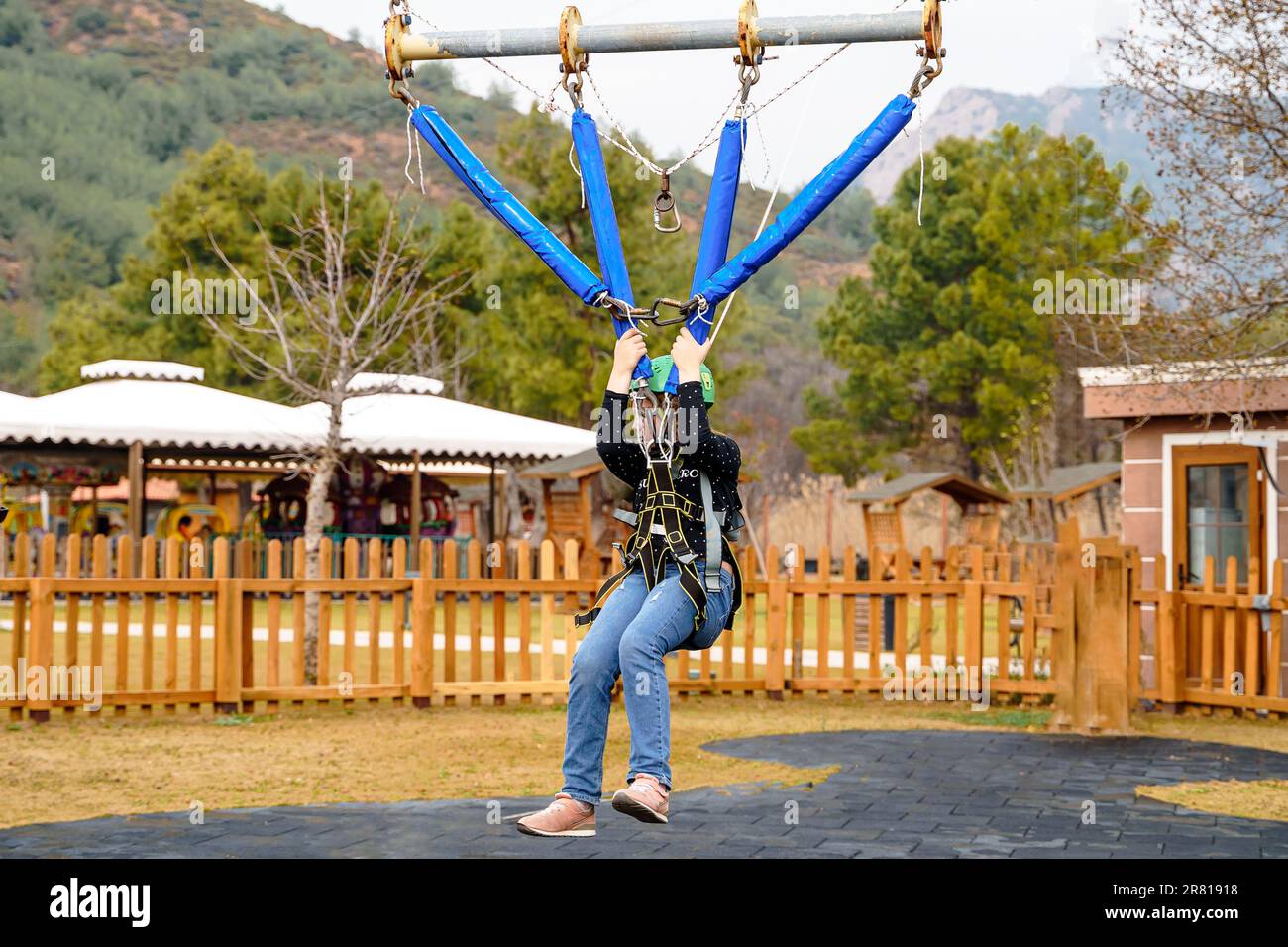 Teenage teen girl bungee flying in rope amusement park. Climbing ...