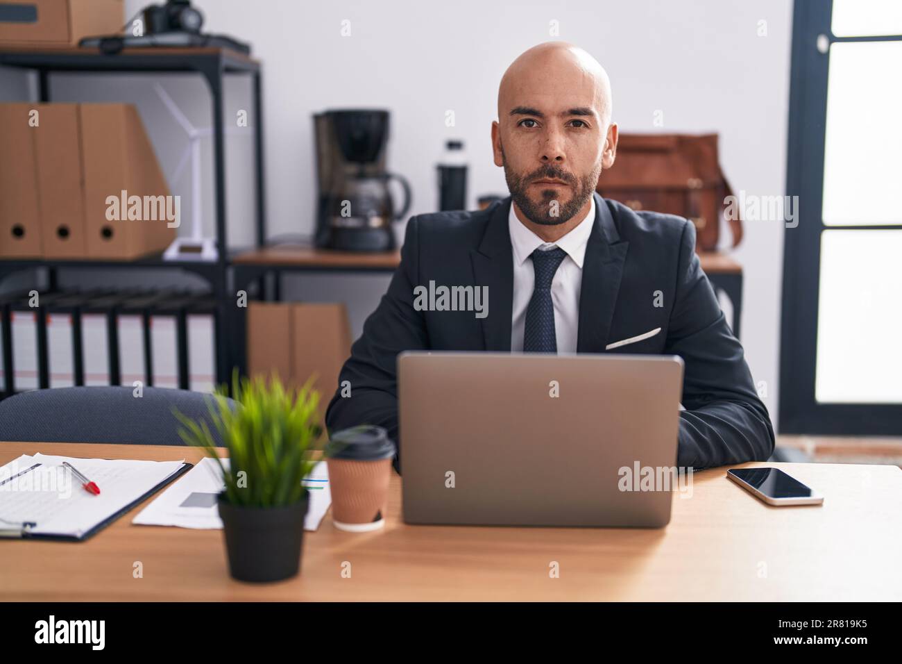 Middle age bald man working at the office thinking attitude and sober ...