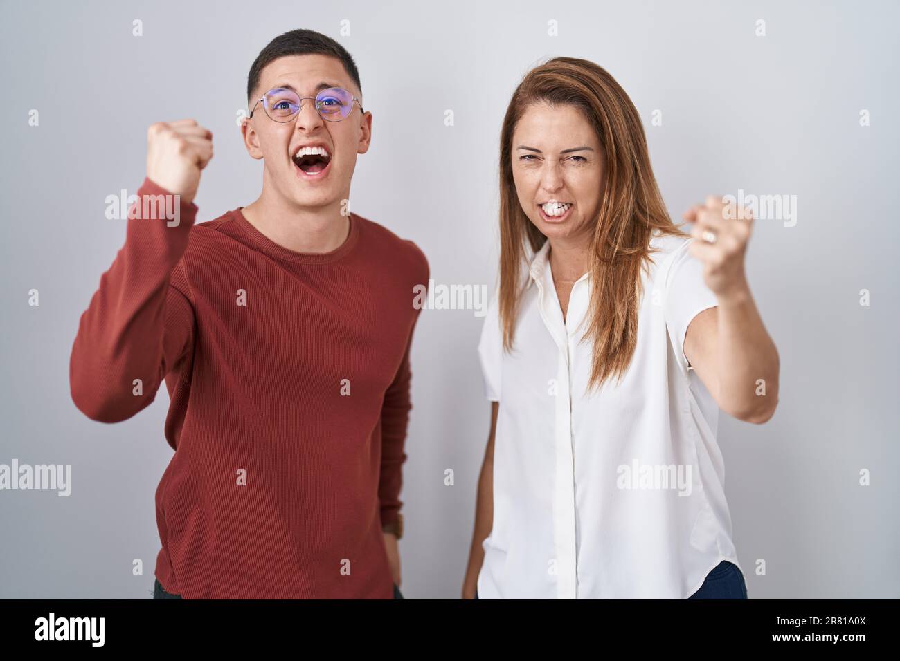 Mother and son standing together over isolated background angry and mad ...
