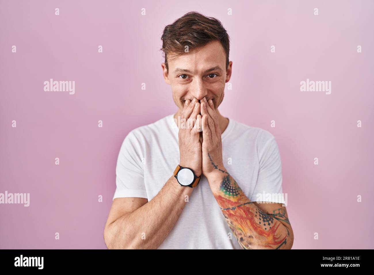 Caucasian man standing over pink background laughing and embarrassed ...
