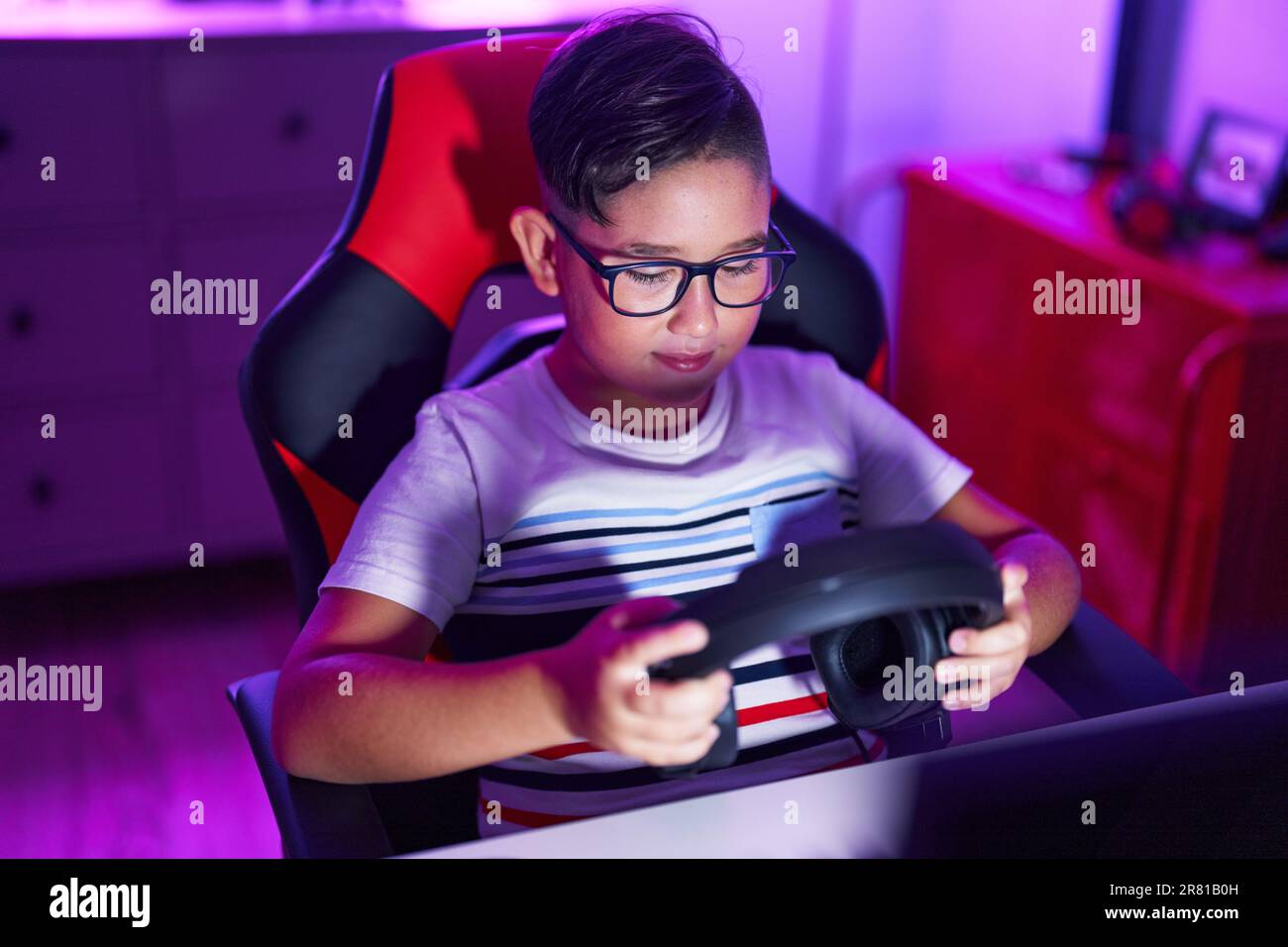 Adorable hispanic boy streamer smiling confident holding headphones at ...