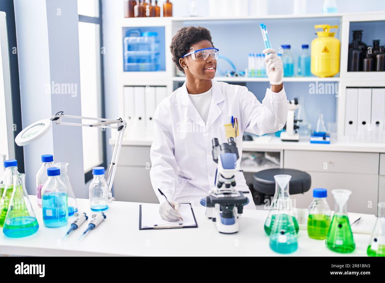 African american woman wearing scientist uniform write on clipboard ...