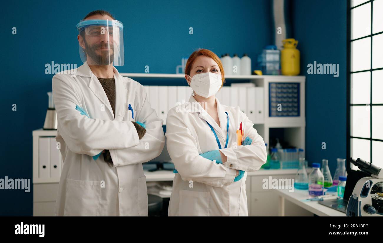 Man and woman wearing sciencist uniform standing with arms crossed ...
