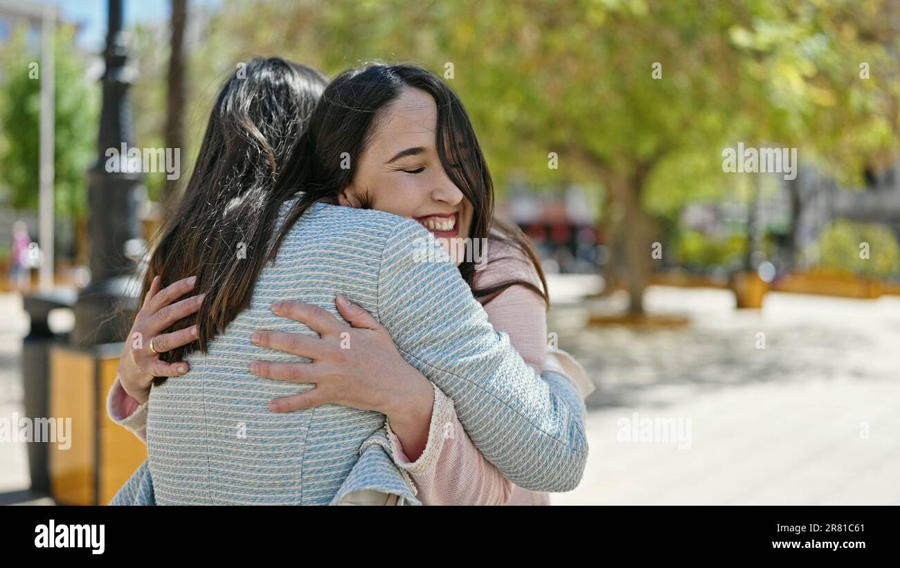 Two women hugging each other at park Stock Photo - Alamy