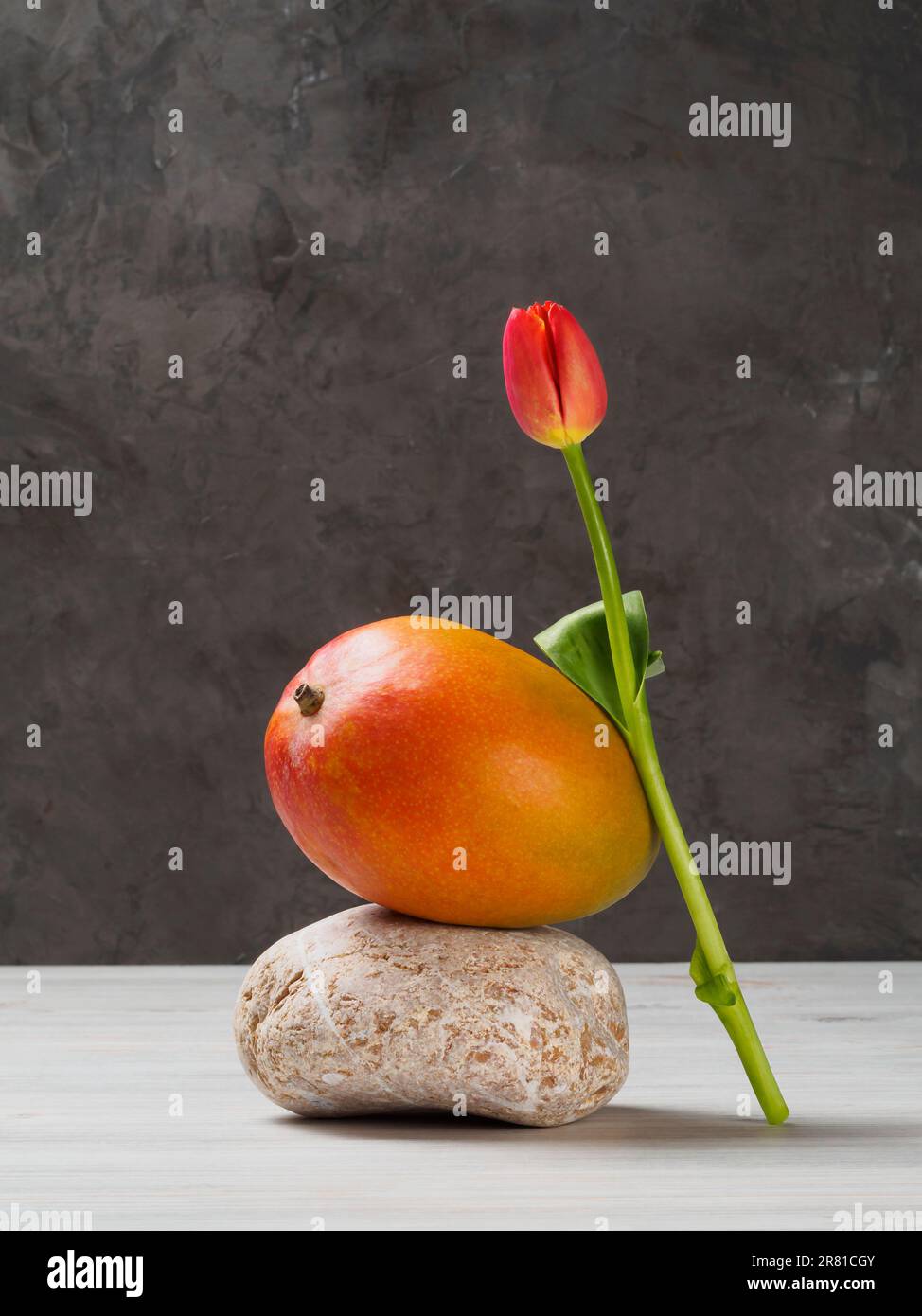 balance of tulip, mango and stone Stock Photo - Alamy