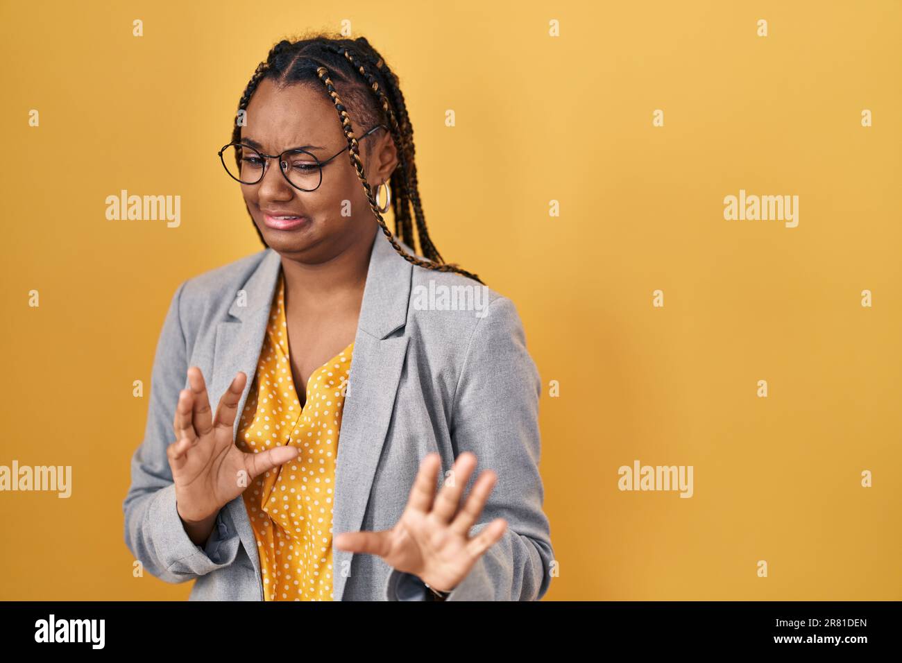 African american woman with braids standing over yellow background ...
