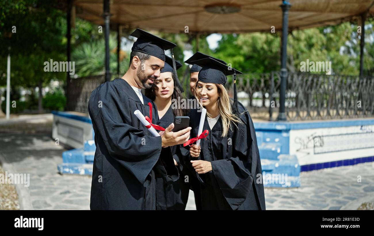 Group of people students graduated holding diploma looking smartphone ...
