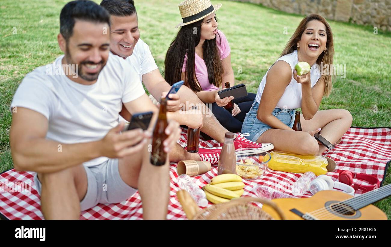 Group of people having picnic using smartphones and touchpad at park Stock Photo - Alamy