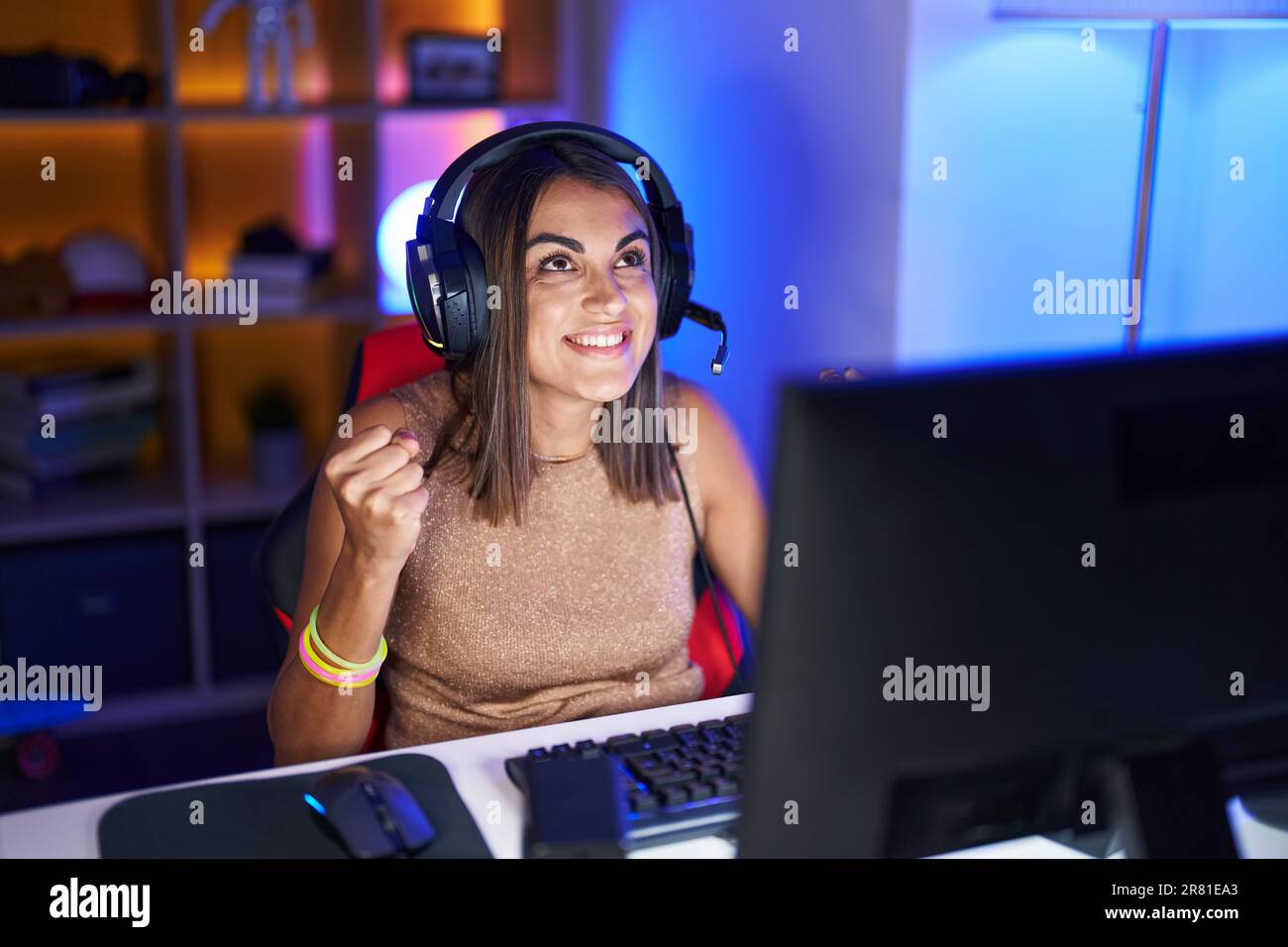 Young beautiful hispanic woman streamer playing video game with winner ...