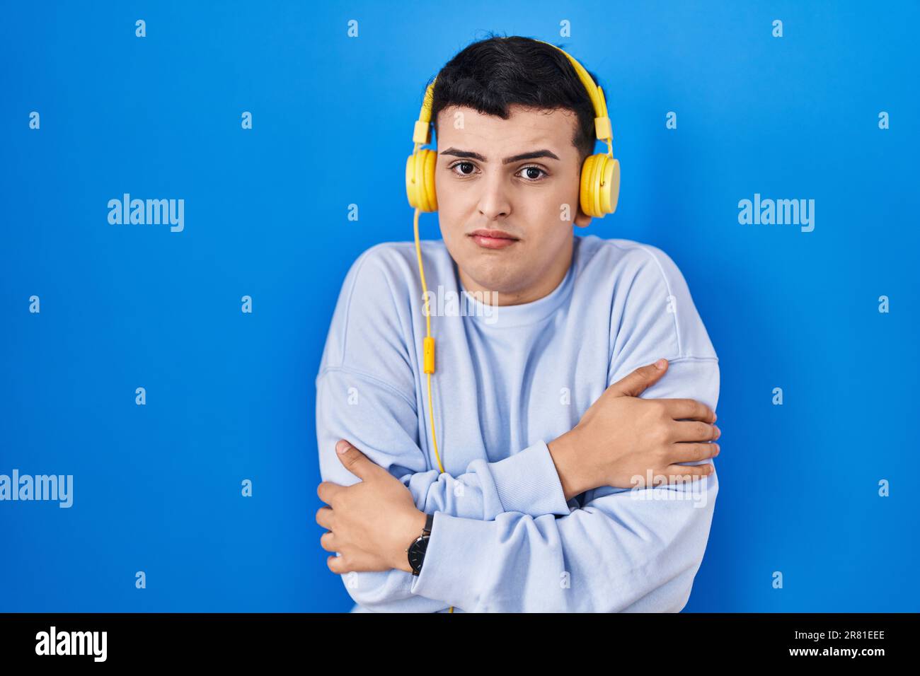 Non binary person listening to music using headphones shaking and ...