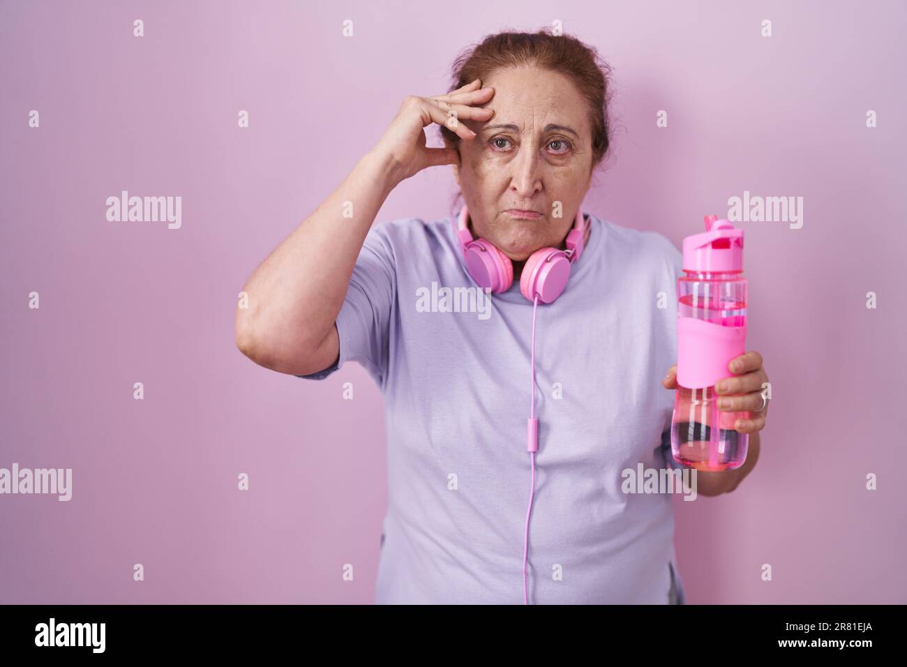Senior woman wearing sportswear and headphones worried and stressed ...