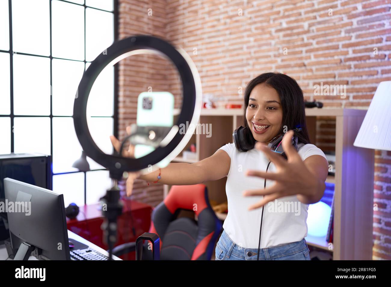 Young arab woman influencer recording herself with smartphone looking ...