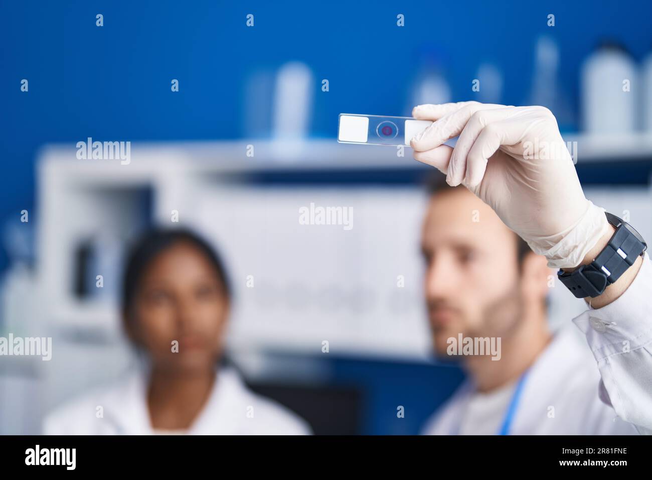 Man and woman scientists holding sample working at laboratory Stock ...