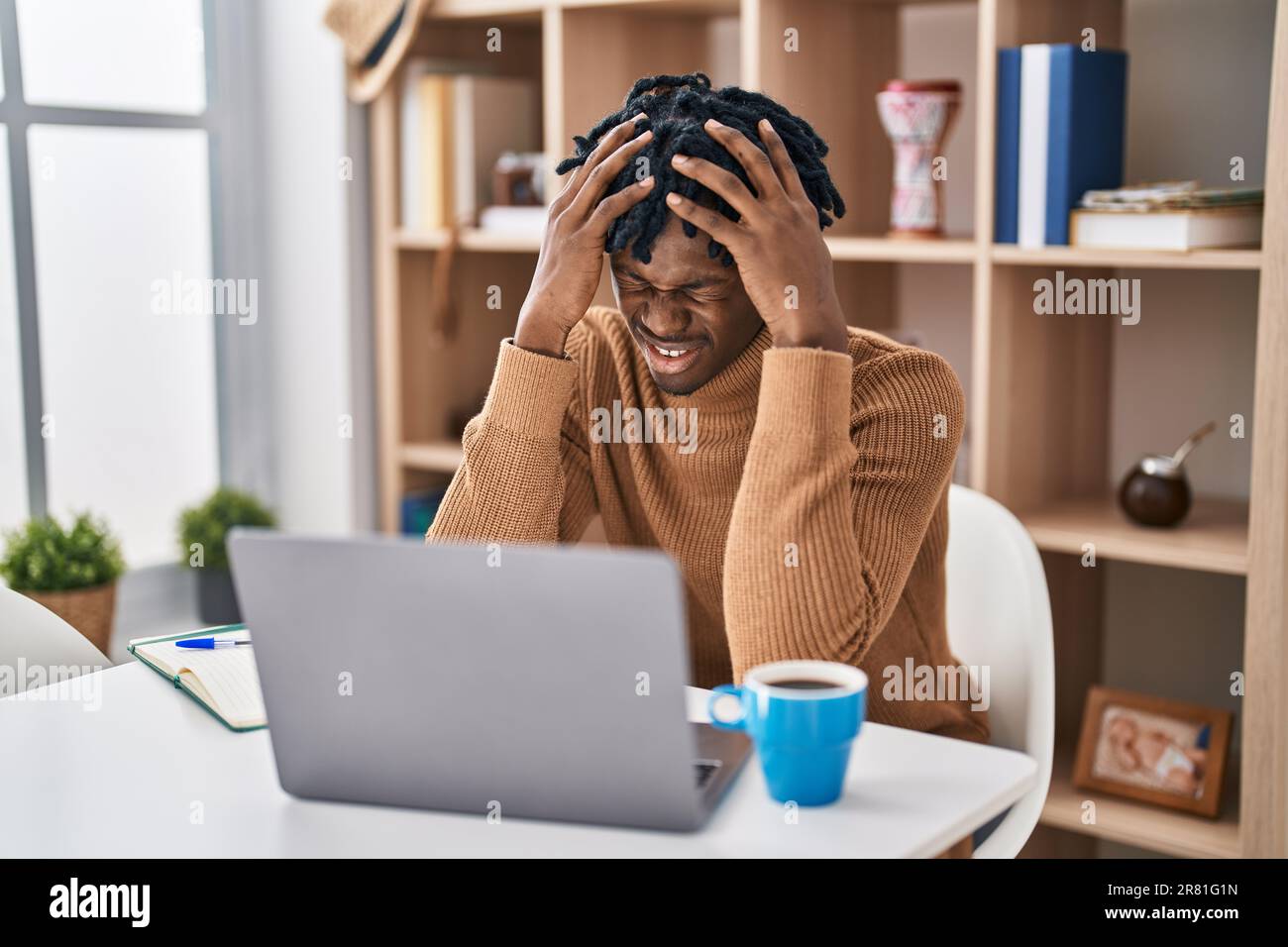 Young african man with dreadlocks working using computer laptop ...