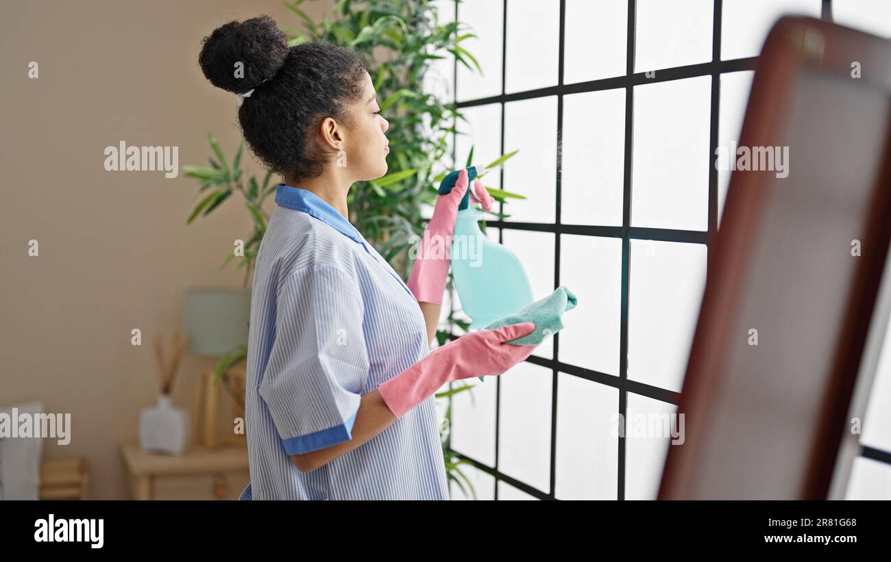 African american woman clean professional cleaning window at hotel room ...
