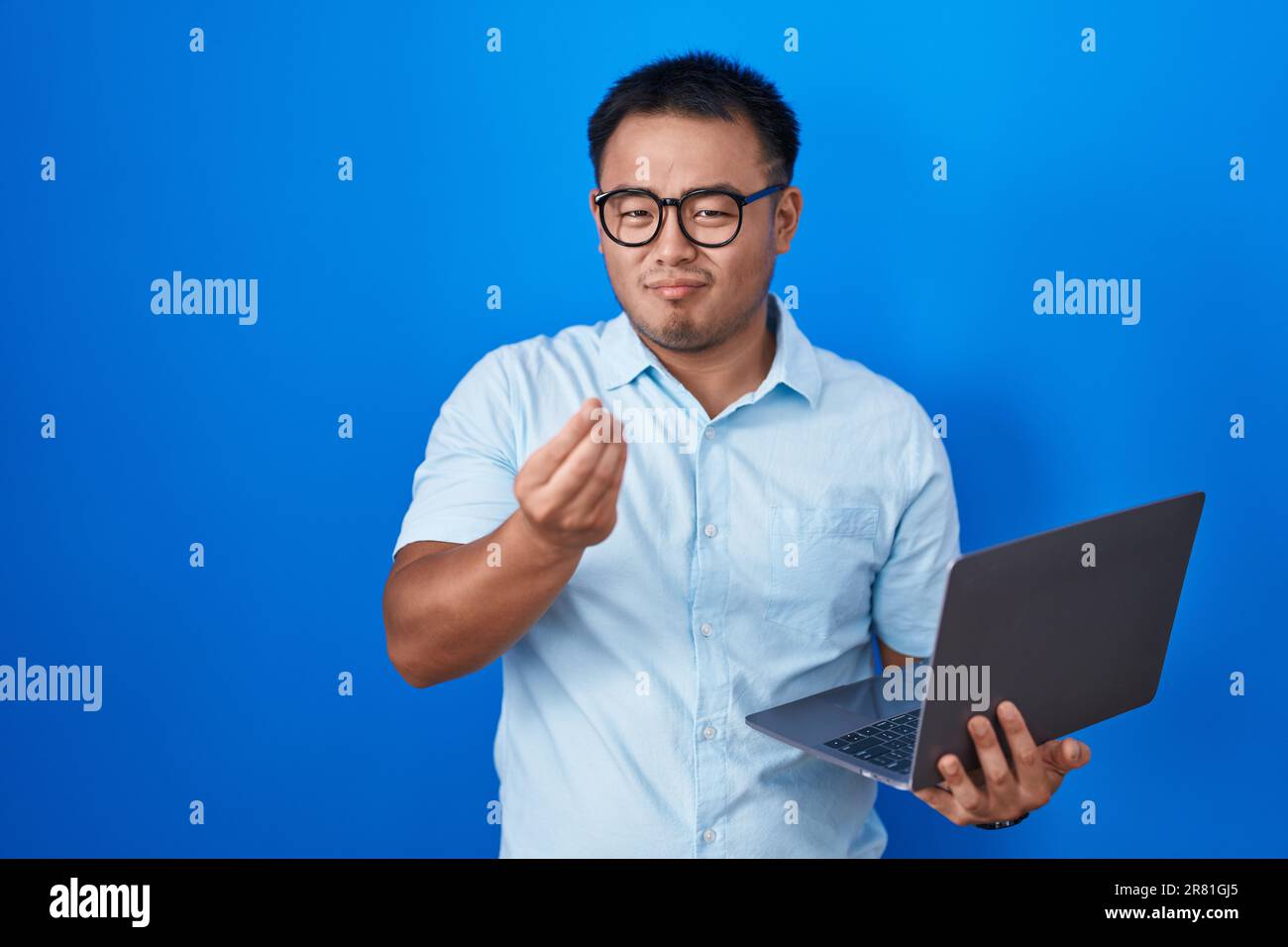 Chinese young man using computer laptop doing money gesture with hands ... Chinese young man using computer laptop doing money gesture with hands ...