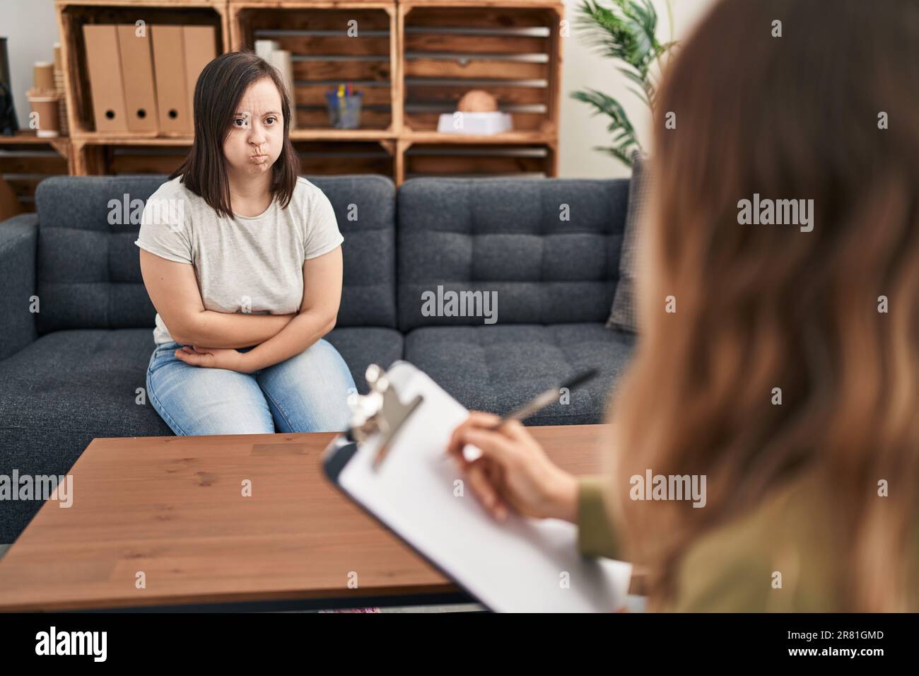 Hispanic girl with down syndrome doing therapy puffing cheeks with ...