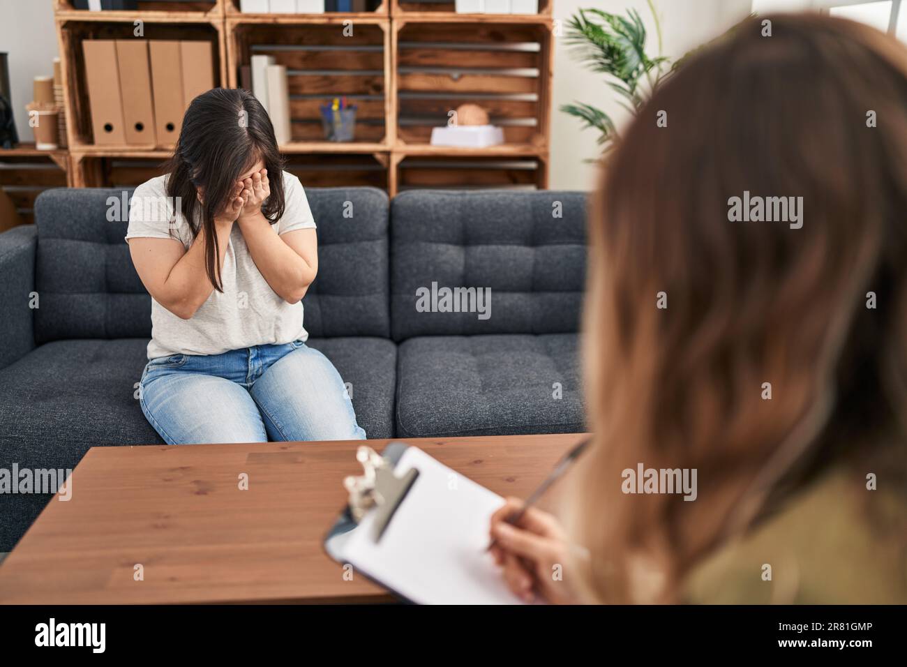 Hispanic girl with down syndrome doing therapy with sad expression ...