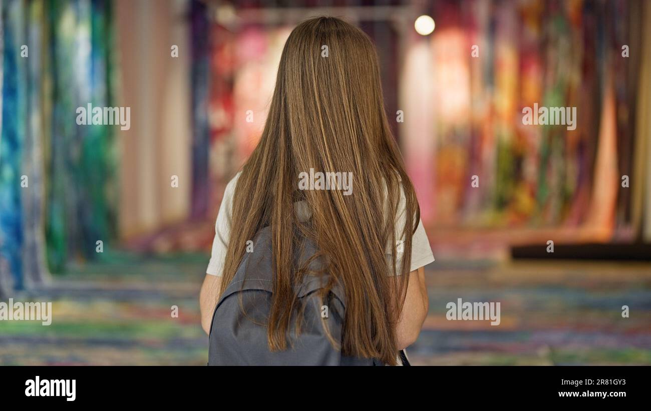 Young beautiful girl student wearing backpack standing backwards at art ...