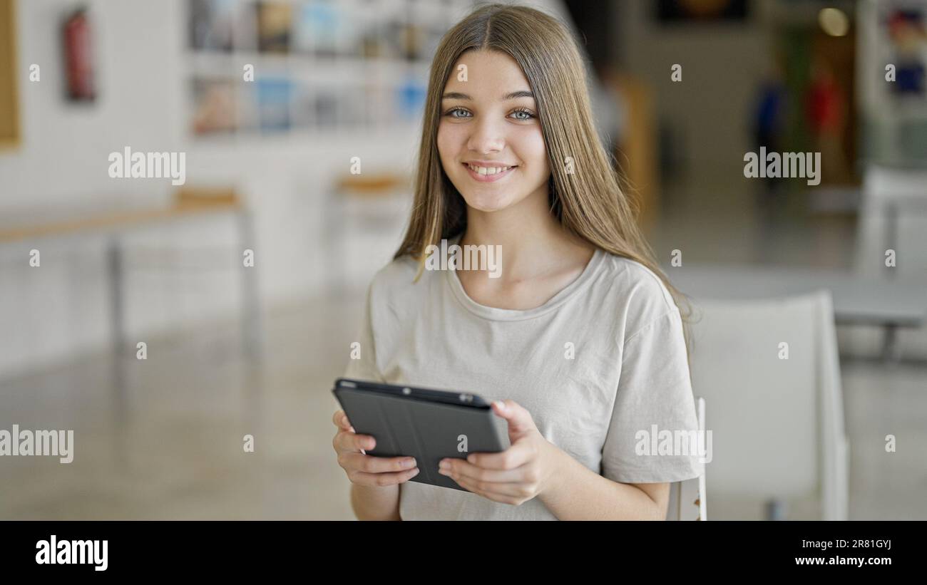 Young beautiful girl student using touchpad studying at library Stock Photo - Alamy