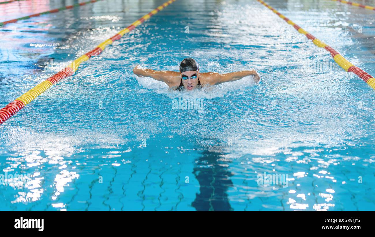 Well trained professional female swimmer in the butterfly stroke, arms ...