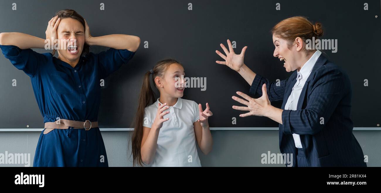 The female teacher screams at the schoolgirl and her mother standing at ...