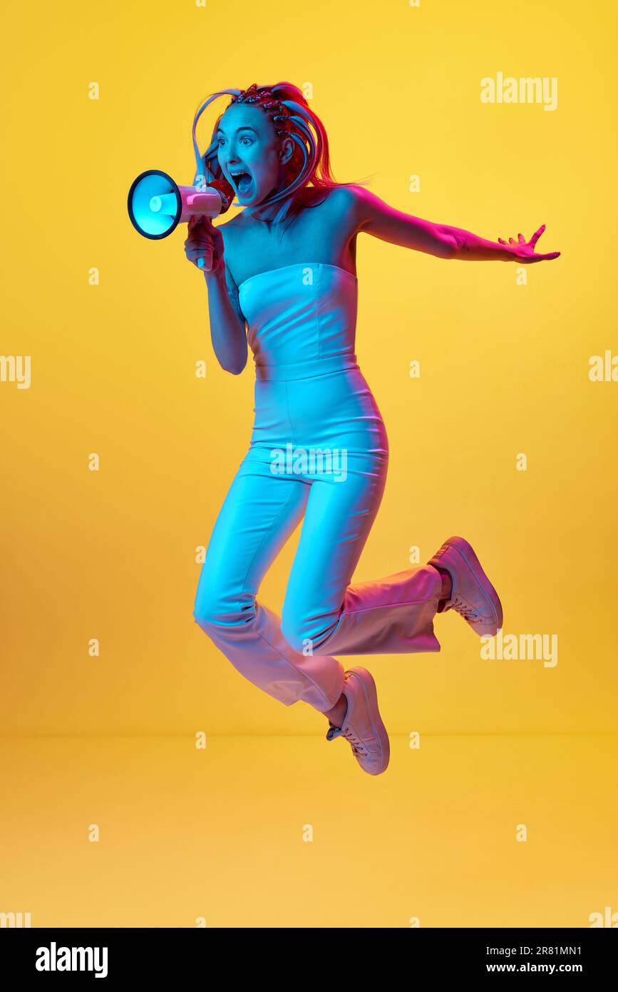Full-length portrait of young emotional girl jumping and emotionally ...