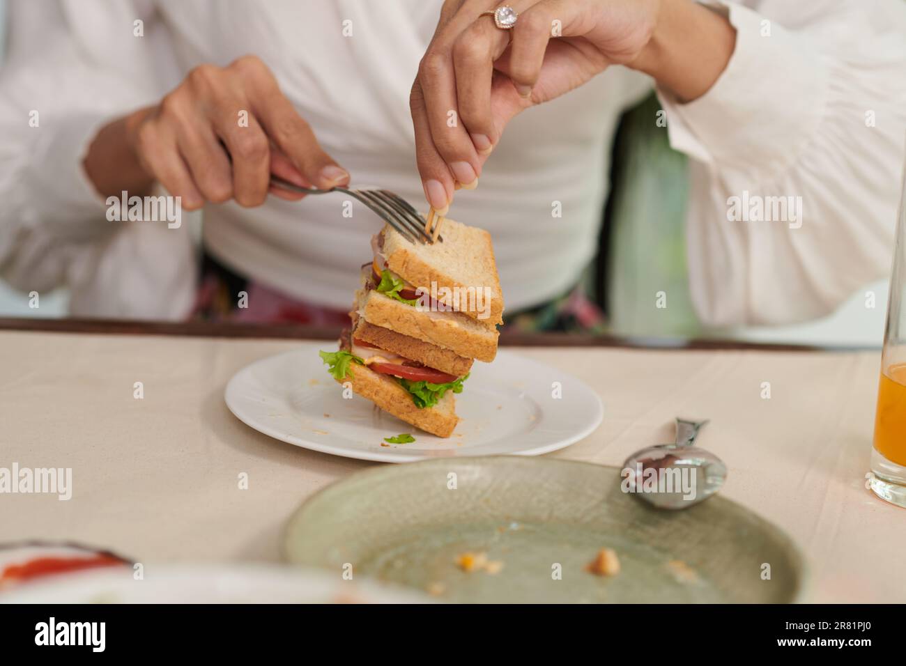 Hands of woman putting sandwich on plate Stock Photo - Alamy