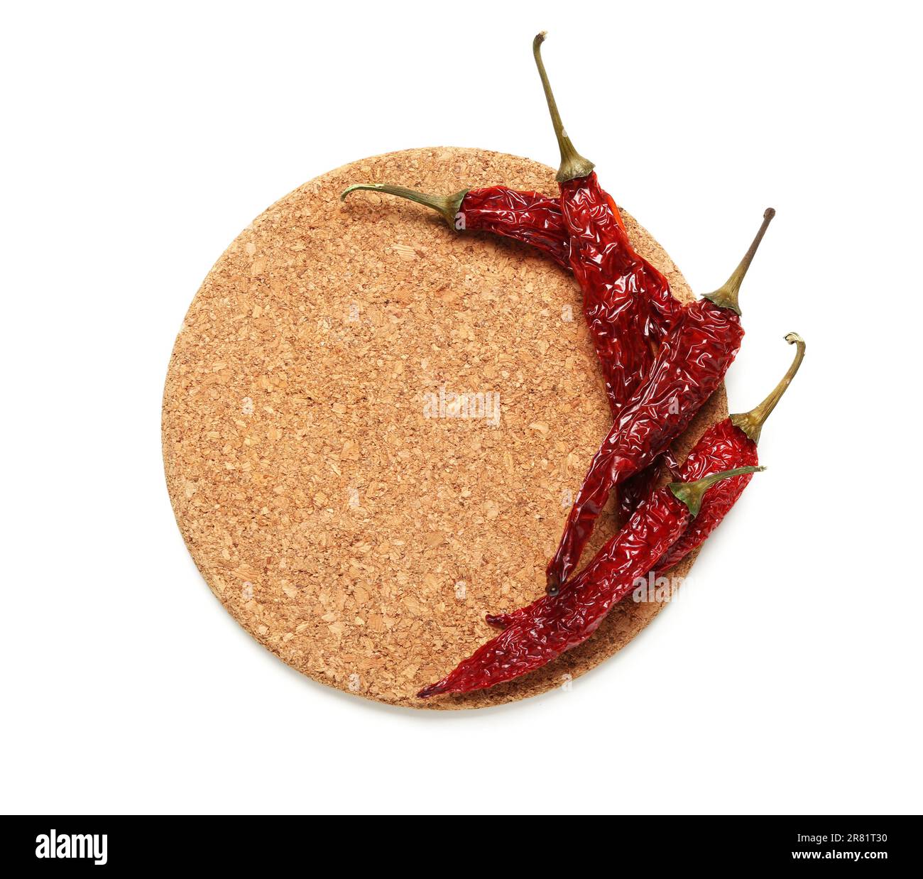 Wooden coaster with dry hot chili peppers on white background Stock ...