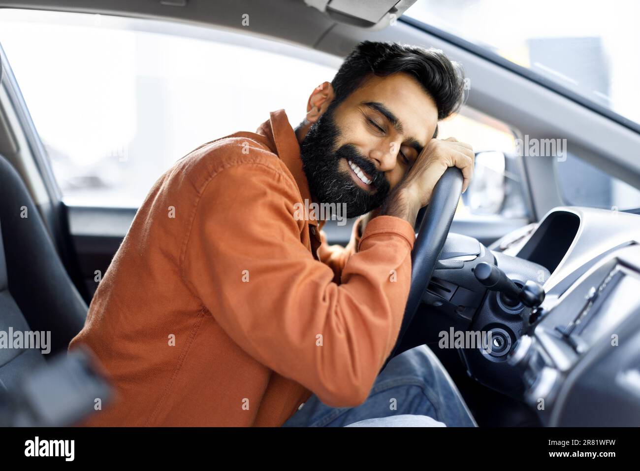 Indian Man Hugging Wheel Of Auto Sitting In Driver's Seat Stock Photo ...