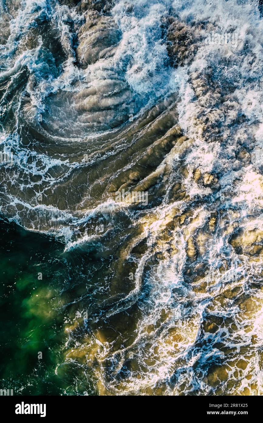 An aerial view of rolling waves and a pattern of white foam created by ...