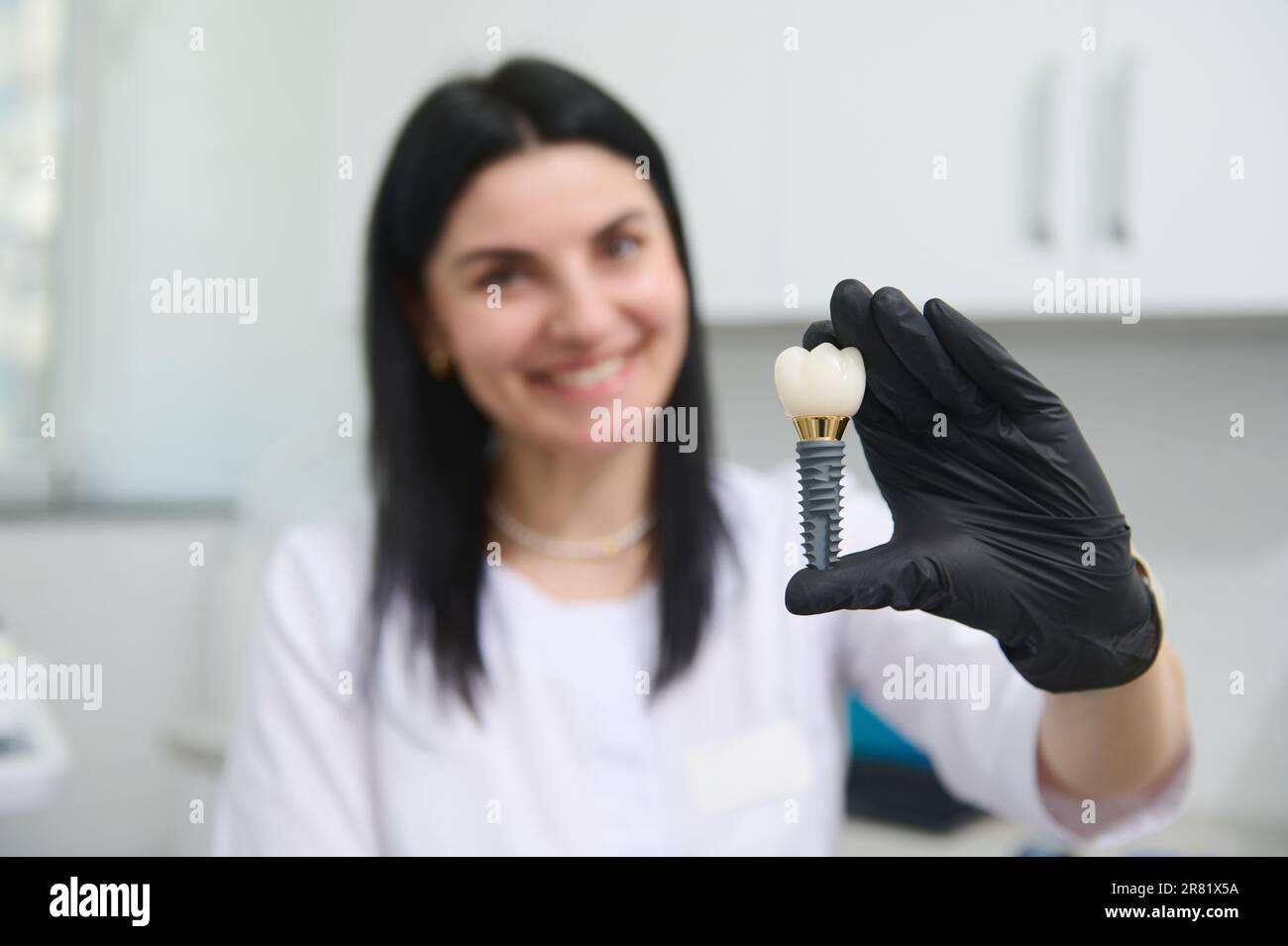 Close-up dentist's hand holding model of tooth showing the mechanism of ...