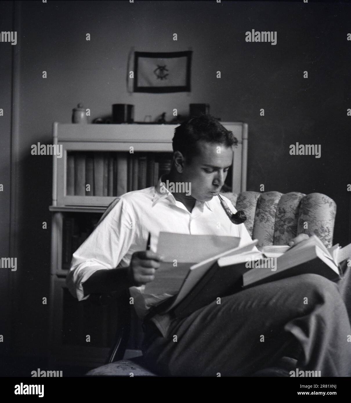 College Student 1949 1950 studying reading in a dorm room with a pipe ...