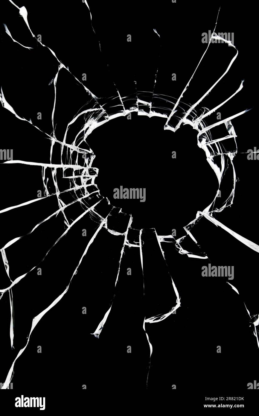 Texture of a crack with a hole in the glass on a black background ...